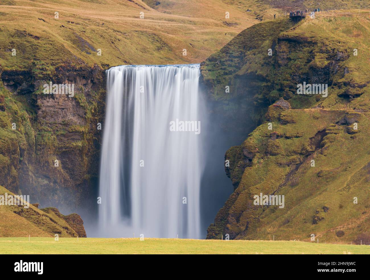 Long exposure, Skogafoss waterfall from the distance with hikers on top ...