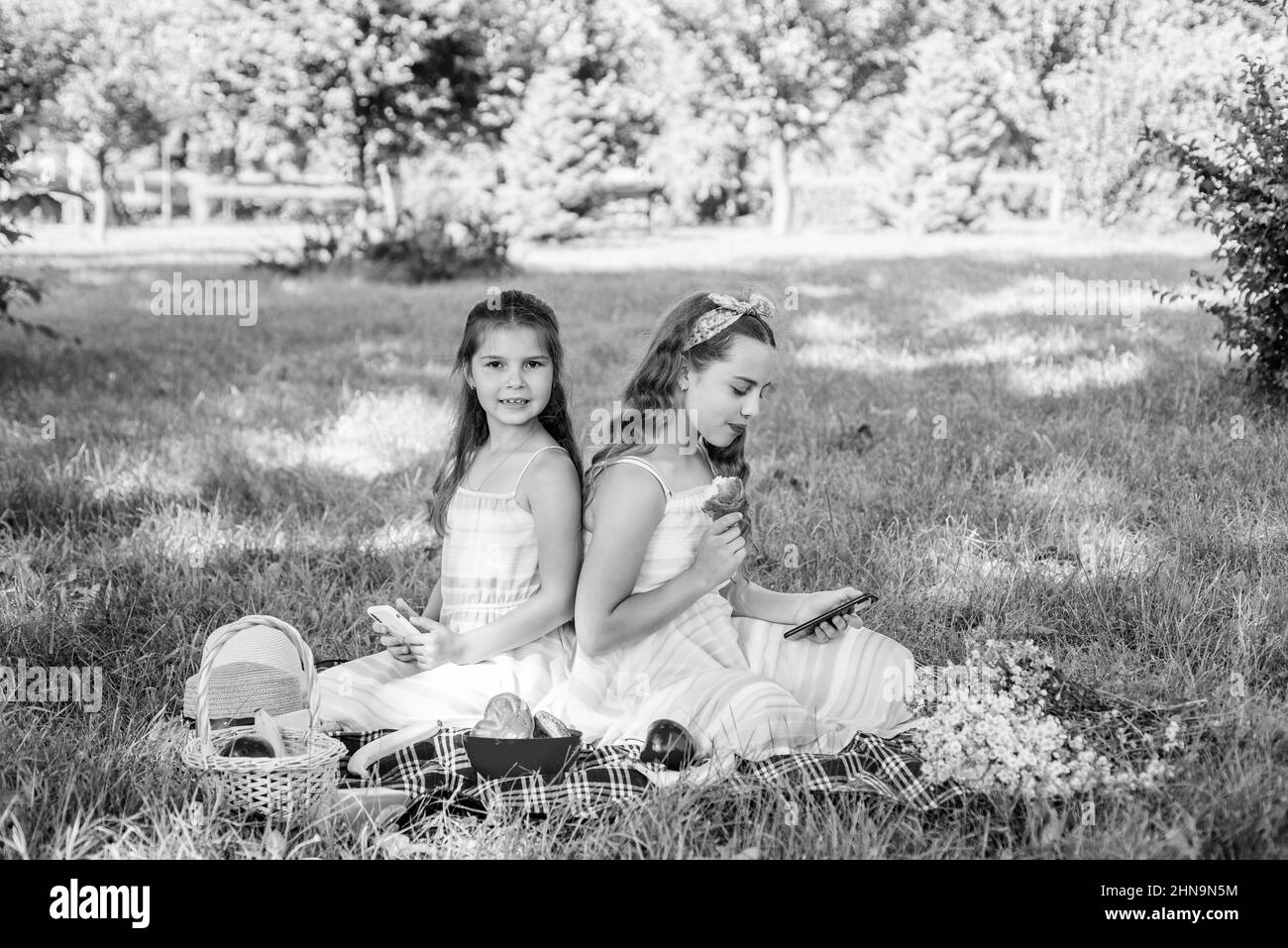 Little girls friends having picnic nature background, idyllic moment ...