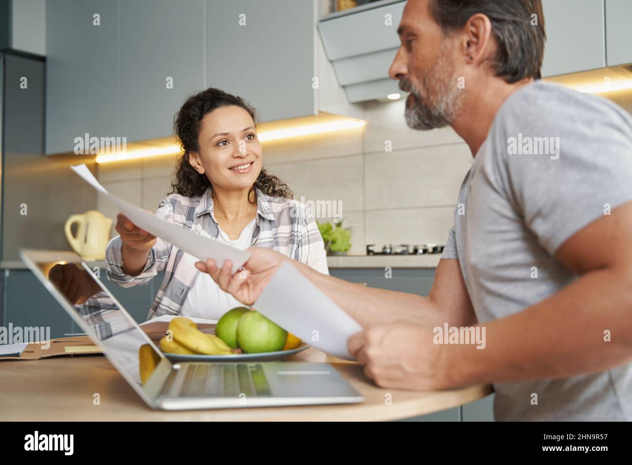 Helpful wife passing document to her husband Stock Photo - Alamy