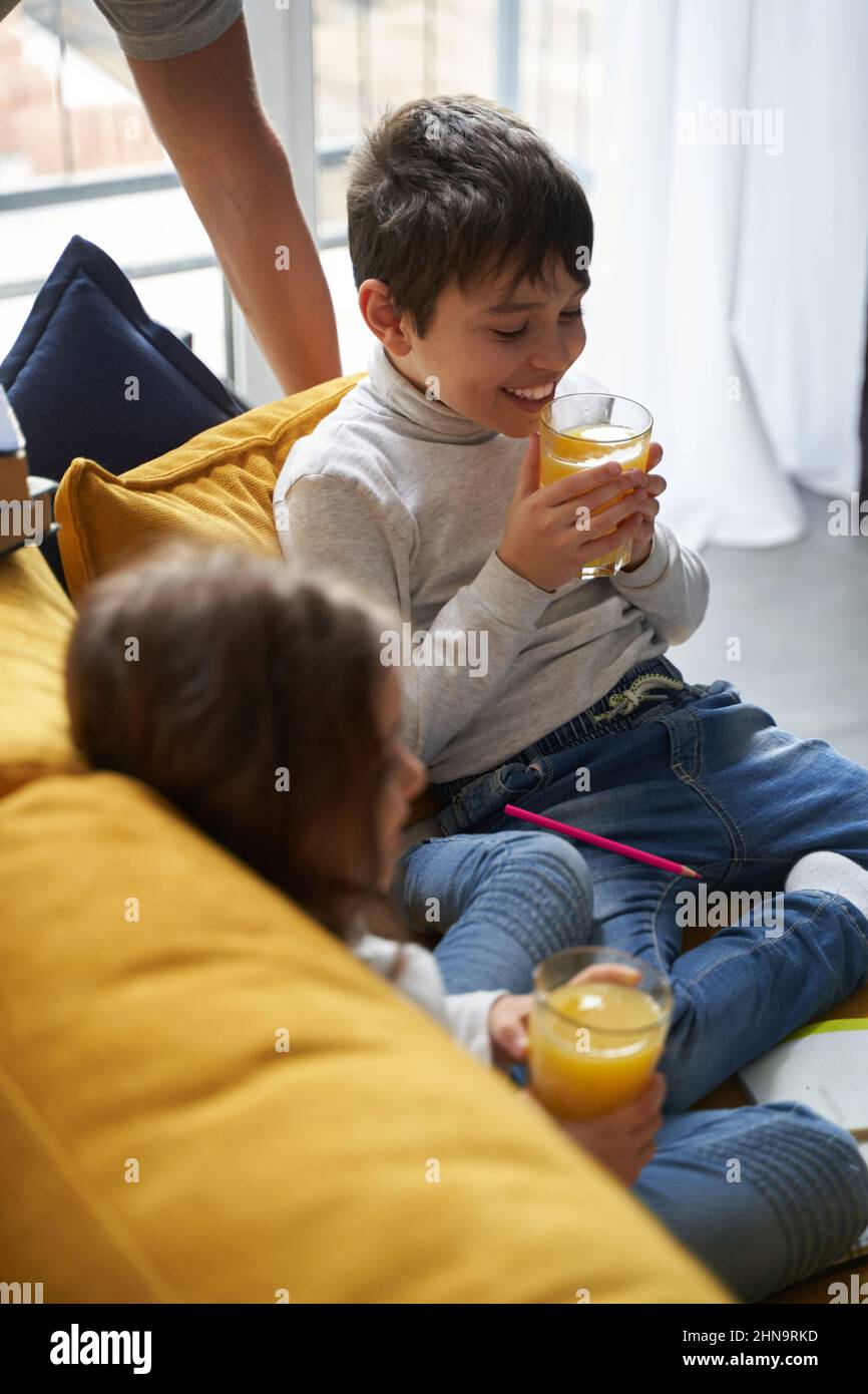 Cheerful boy taking a sip of orange juice Stock Photo - Alamy