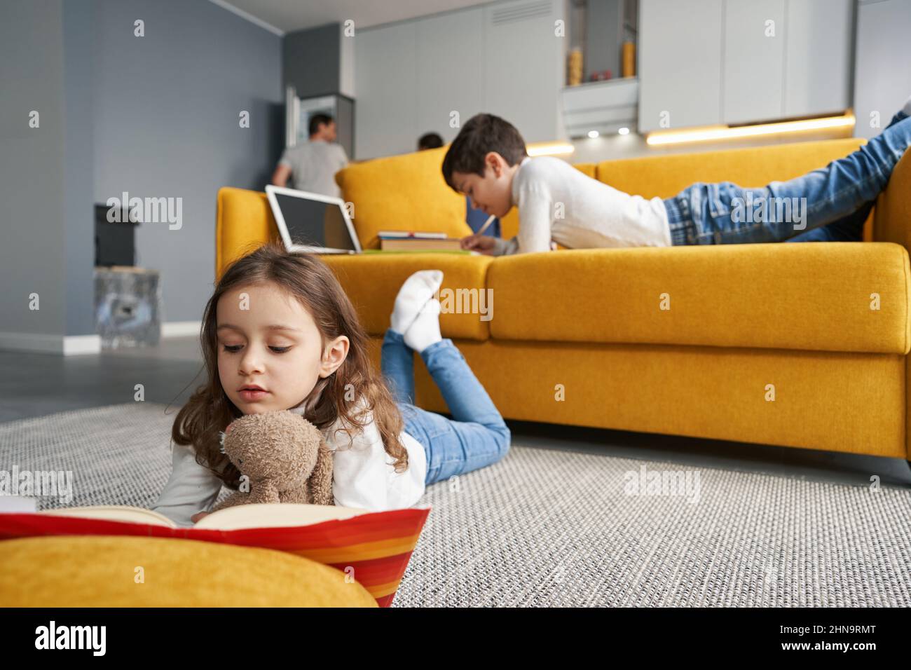 Kid with toy bear reading book and boy writing homework Stock Photo - Alamy