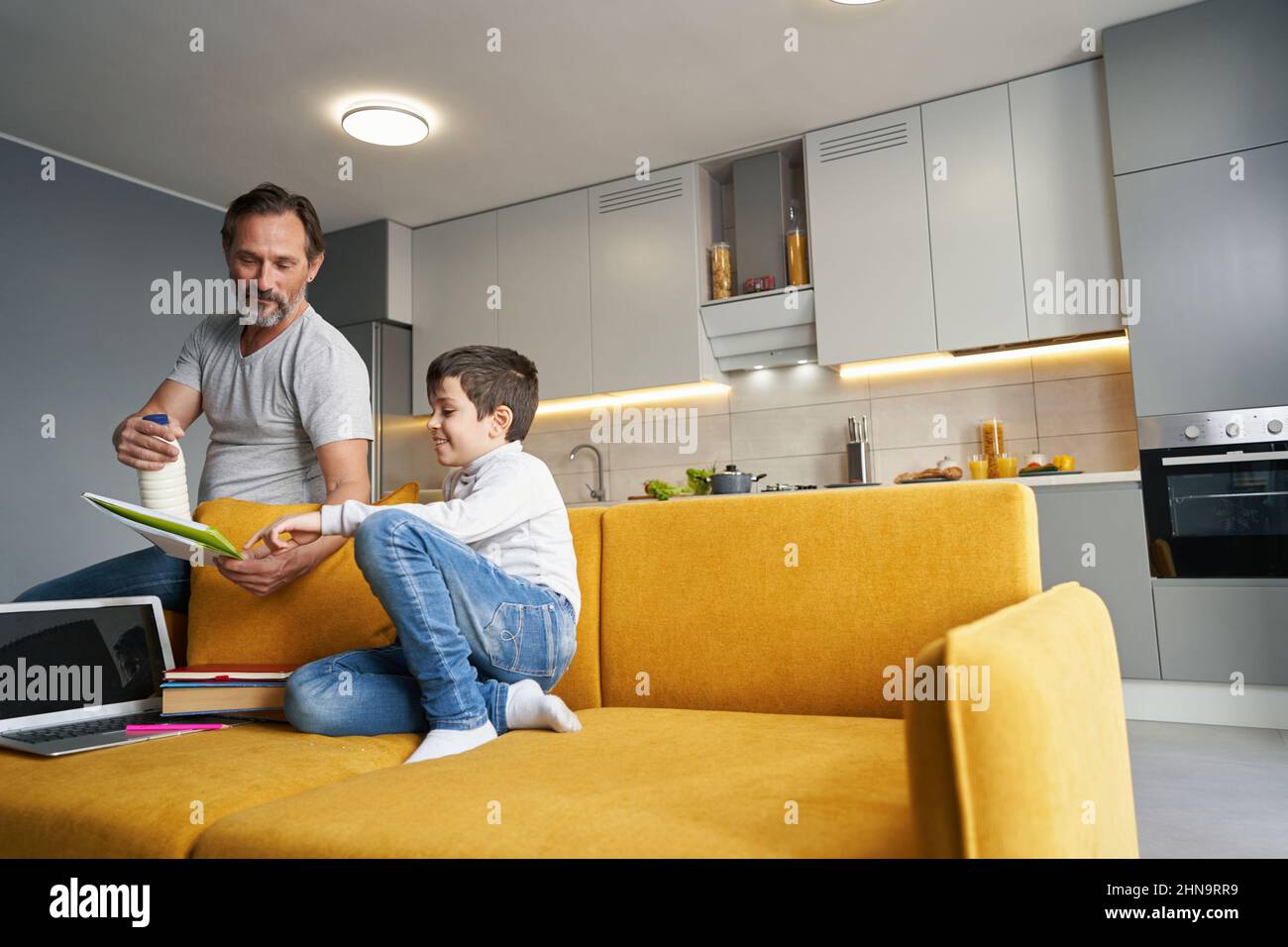 Boy asking father to help with exercise in notepad Stock Photo - Alamy