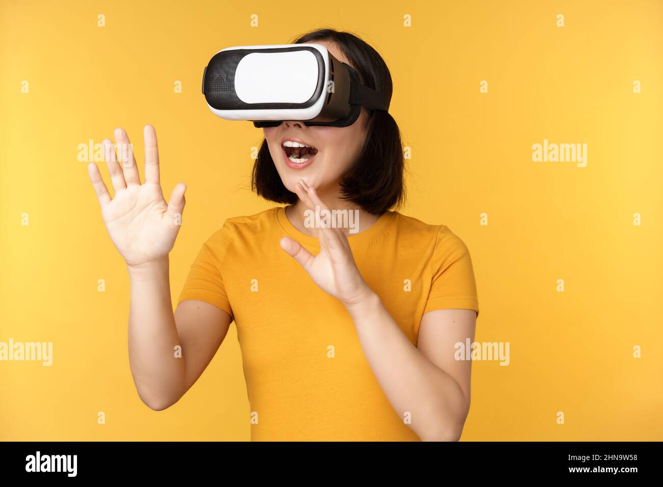 Girl in VR. Beautiful young asian woman, using virtual reality glasses ...
