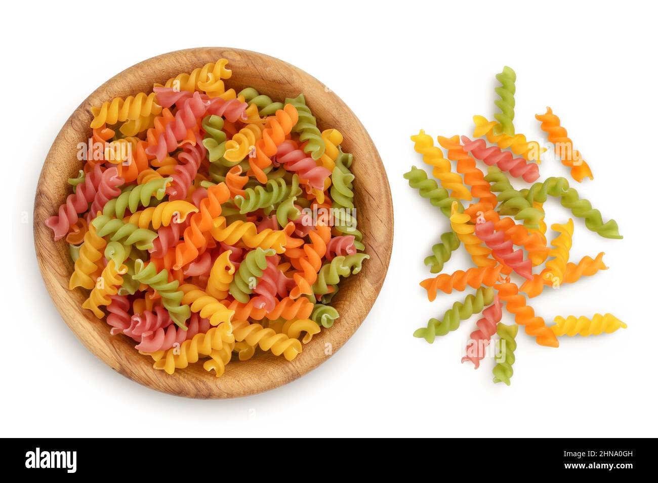 raw Fusilli colored pasta in wooden bowl isolated on white background ...