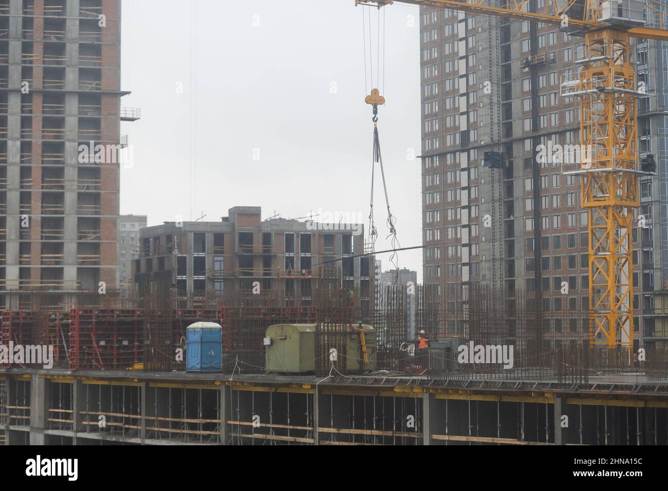 Large residential tower under construction with yellow large cranes ...