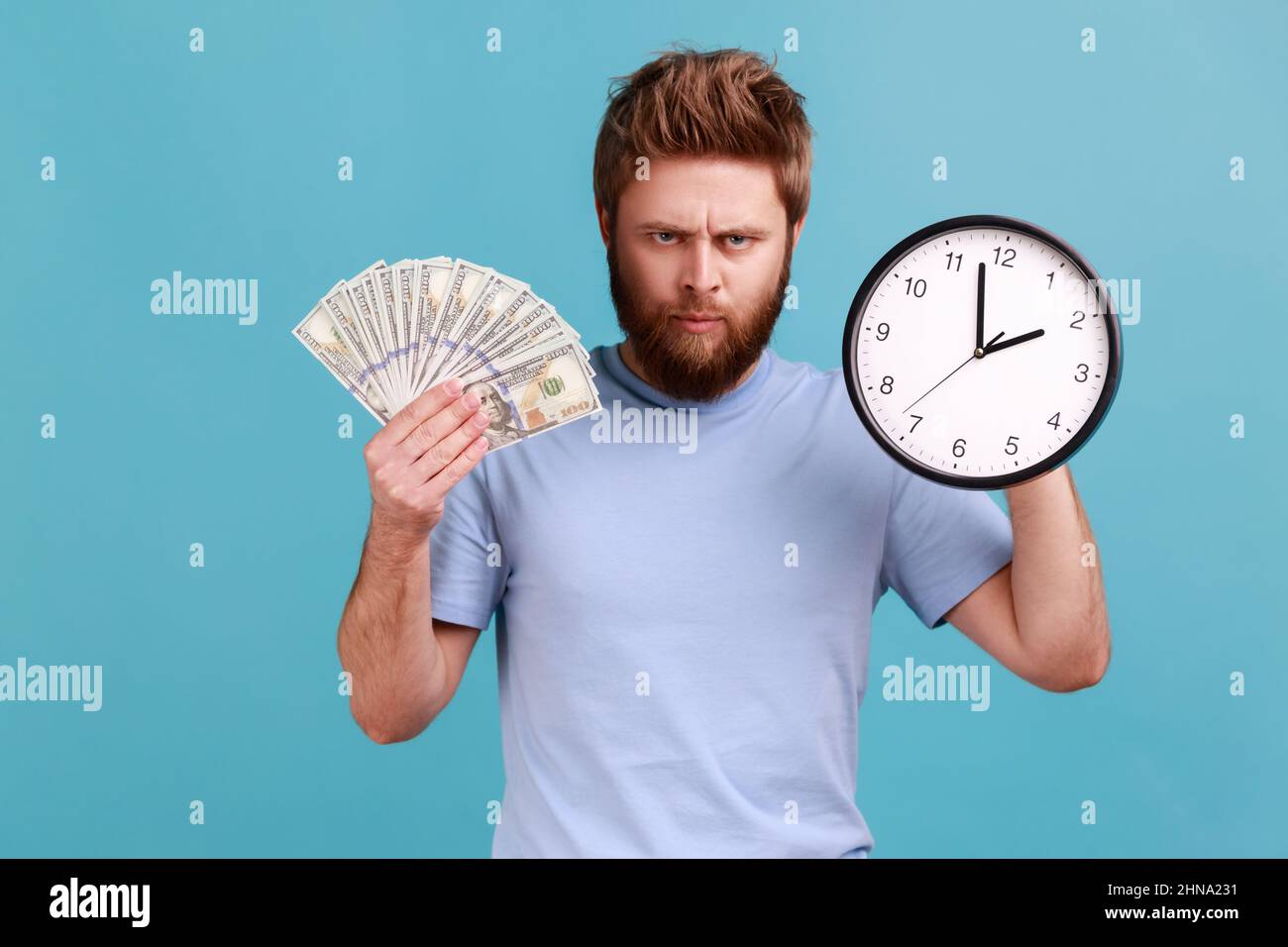 Portrait of angry handsome bearded man holding big fan of dollar ...