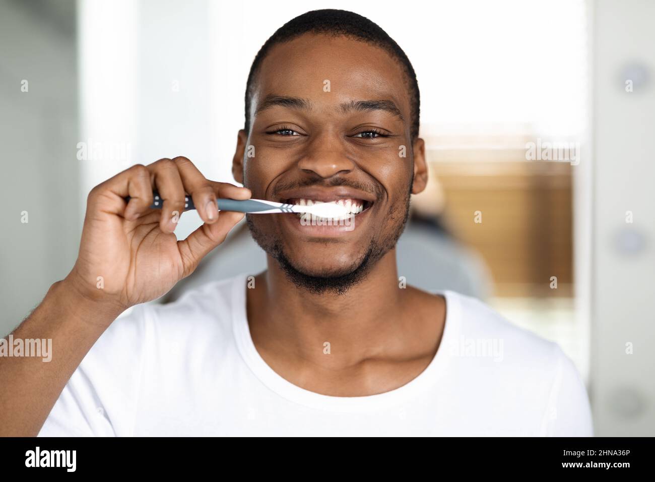 Joyful African American Guy Brushing Teeth With Toothbrush At Home Stock Photo - Alamy