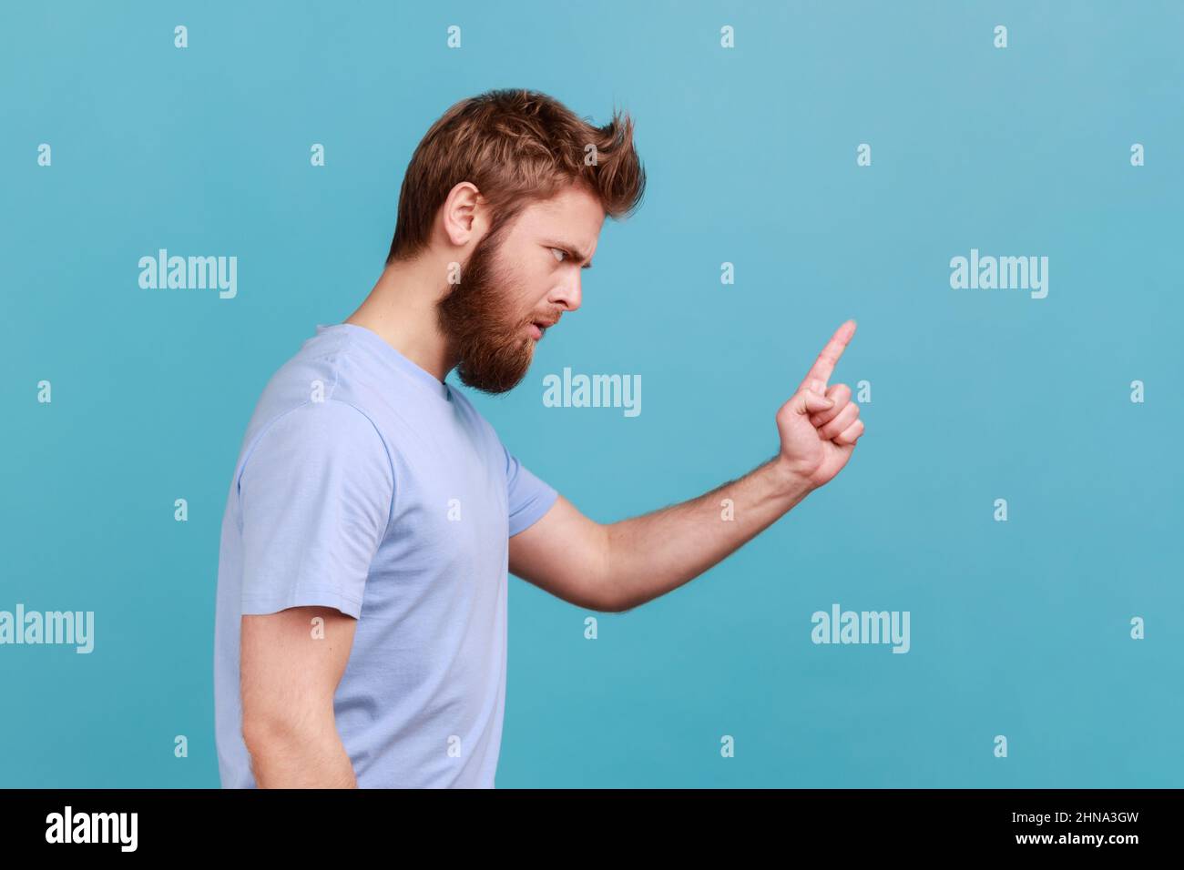 Side view of strict serious young bearded man warning of mistake ...
