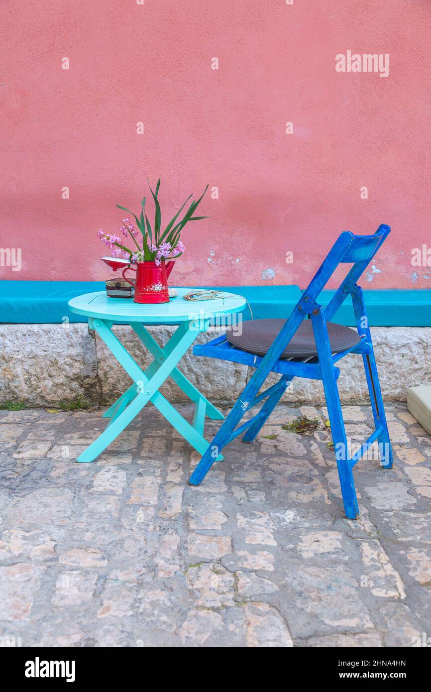 Still life with table and chair at the old color facade of the house ...