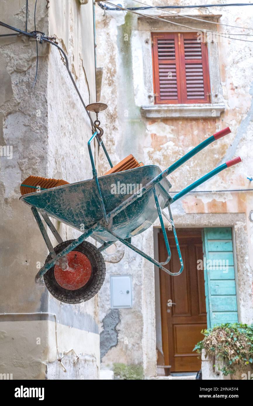 Loaded wheelbarrow at construction works in an ancient street in Rovinj ...