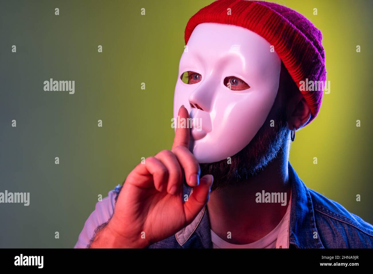 Side view of unknown anonymous man in white mask on face, hiding ...