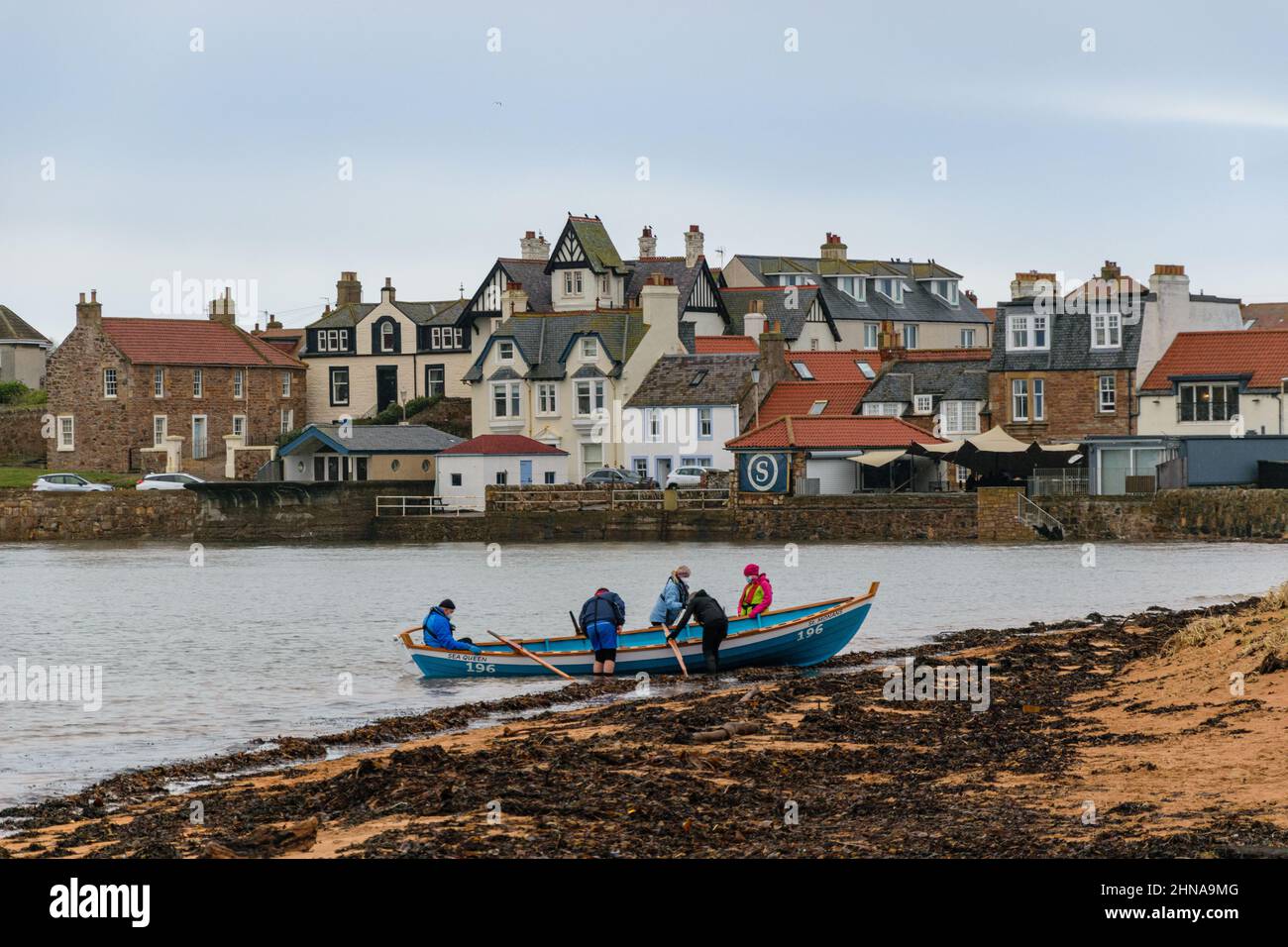 Skiff being readied for rowing practice by members of sailing club in ...
