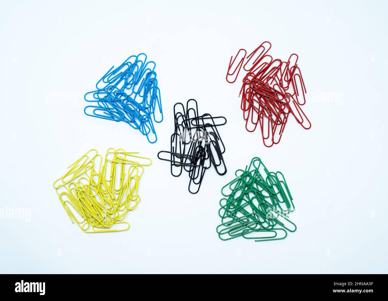 Multi coloured, blue, red, yellow, black and green paper clips in piles ...