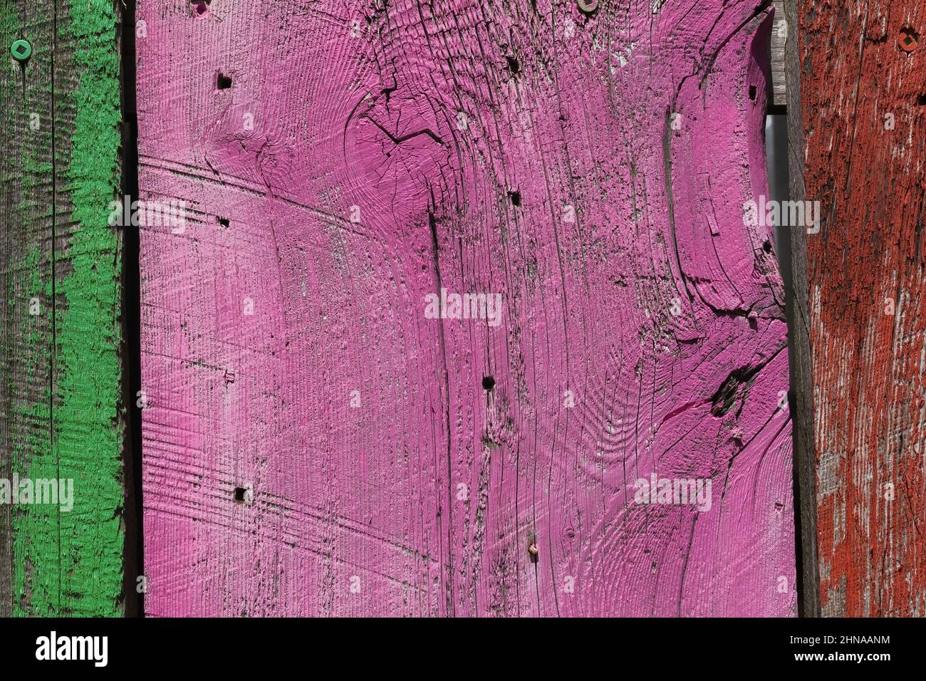 Close-up of grooves and saw marks on surface of pink painted wood plank ...