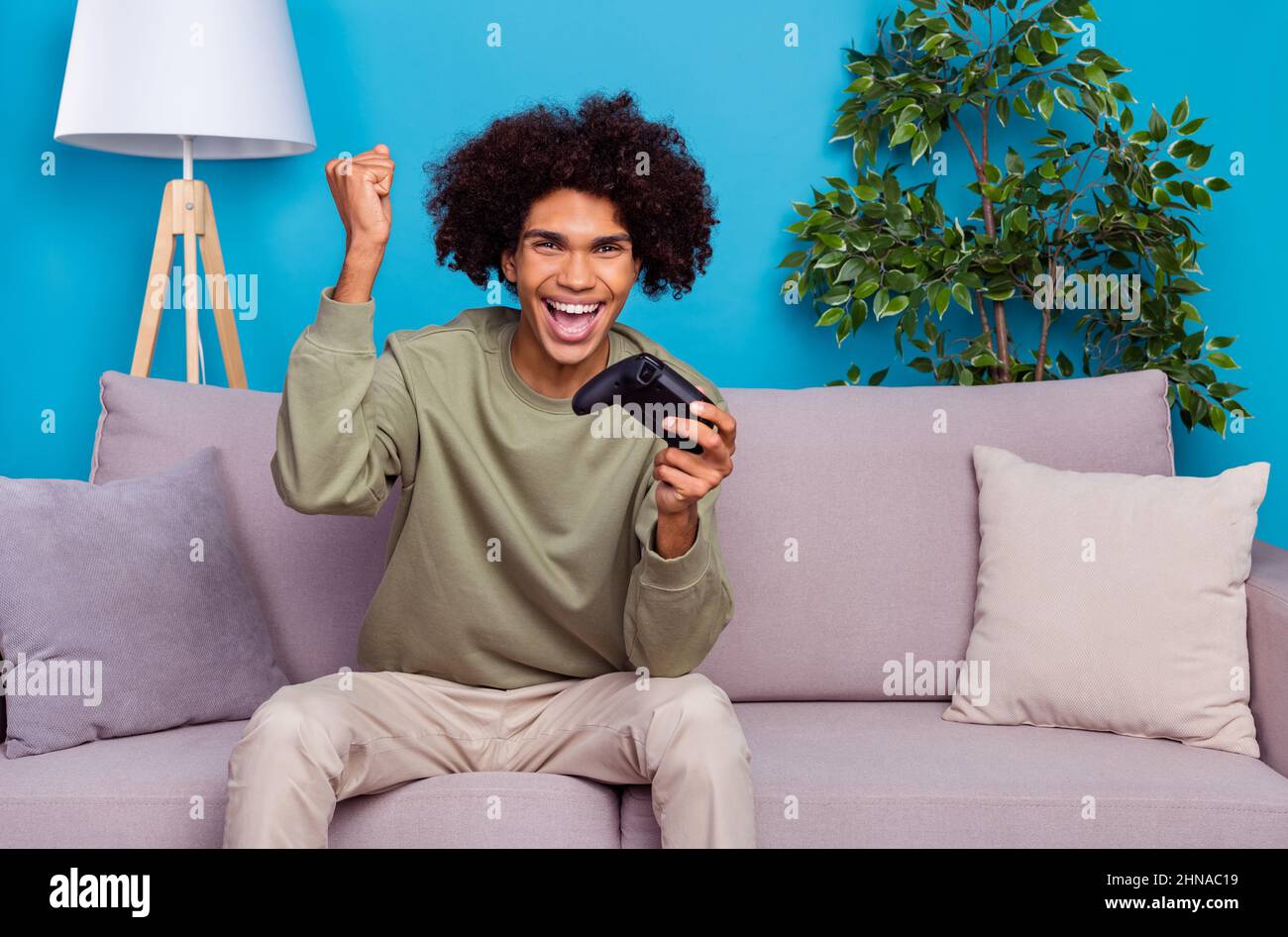 Photo of young cheerful guy rejoice victory fist hand play game lucky ...