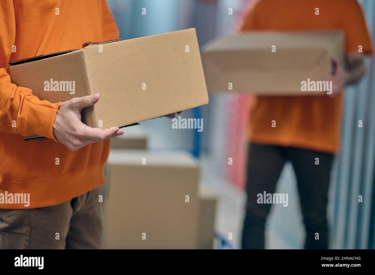 Male workers unloading goods in the warehouse Stock Photo - Alamy