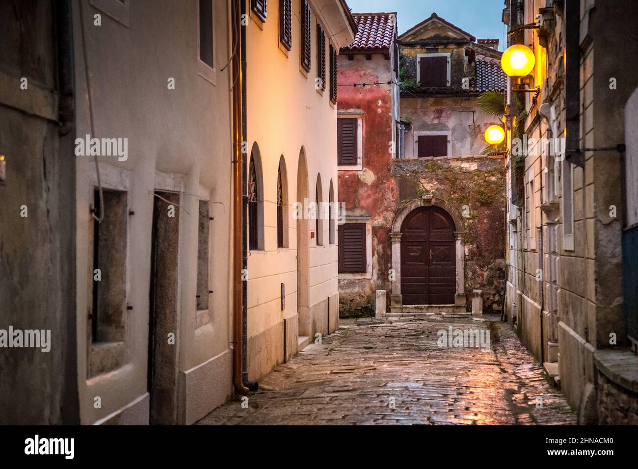 Street in Porec town illuminated by lamps at the evening, Croatia ...