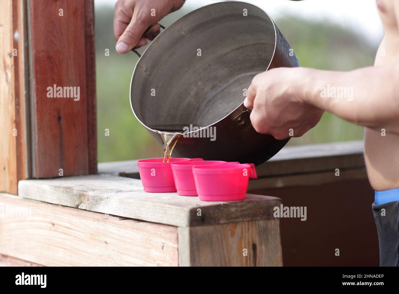 Pouring tea from aluminic pan on picnic Stock Photo - Alamy