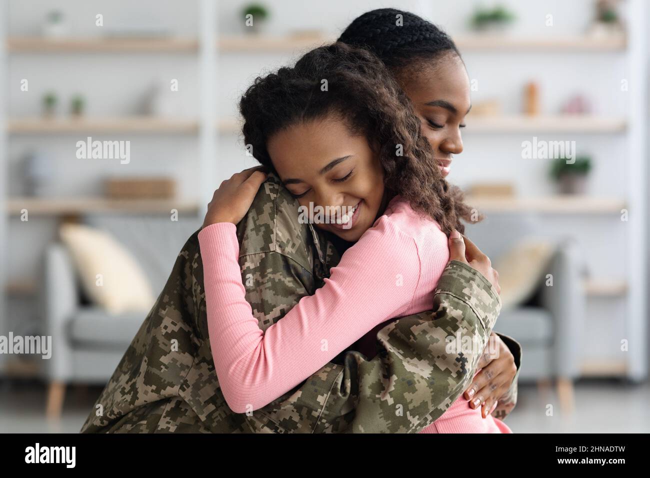 Side view of mom in military uniform hugging child Stock Photo - Alamy