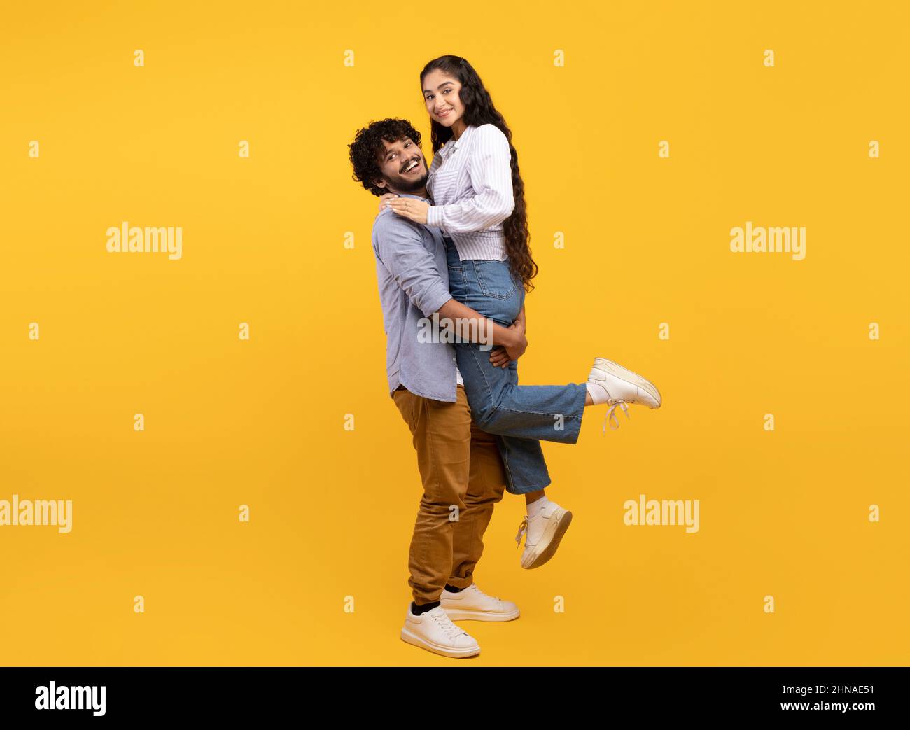 Romantic young indian guy lifting his girlfriend and holding her ...