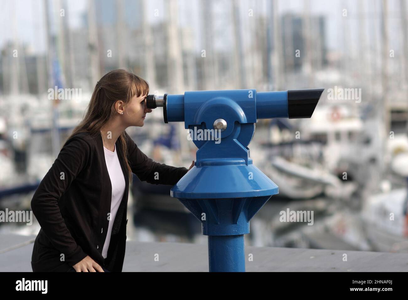 Young woman looks through telescope on city Stock Photo - Alamy