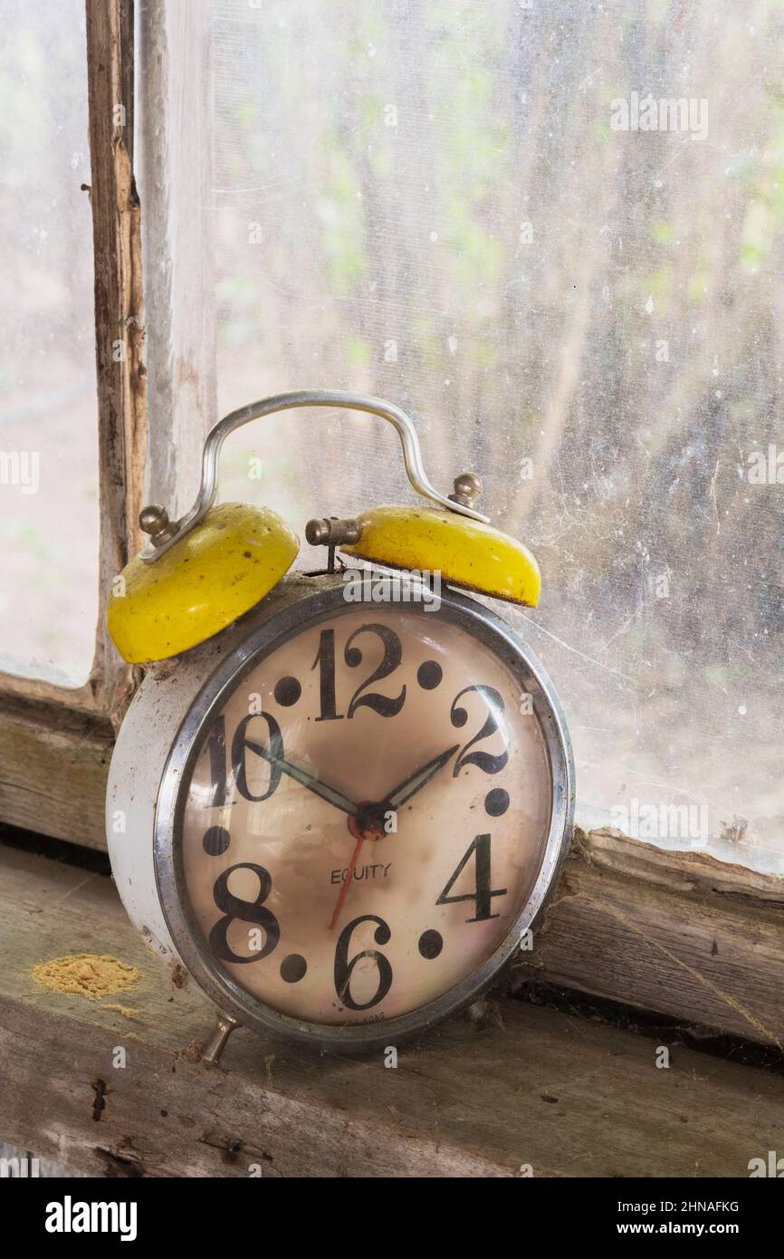 Antique Equity brand mechanical alarm clock on windowsill inside old ...