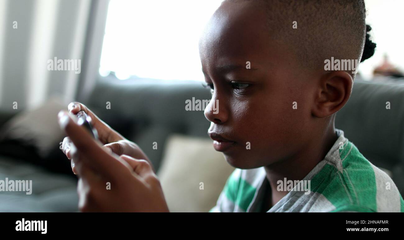 African boy playing game on cellphone at home Stock Photo - Alamy