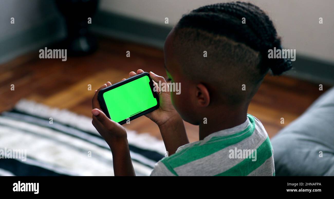 African child holding cellphone with mock-up green screen Stock Photo ...