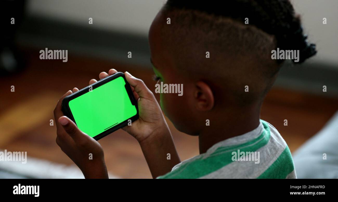 African child holding cellphone with mock-up green screen Stock Photo ...