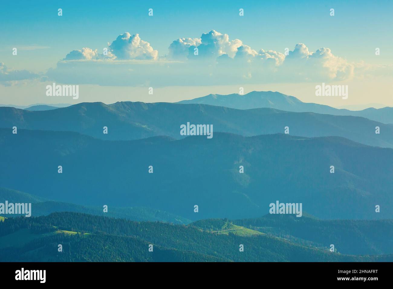 View to blue ranges of mountains under beautiful cloudy sky before ...