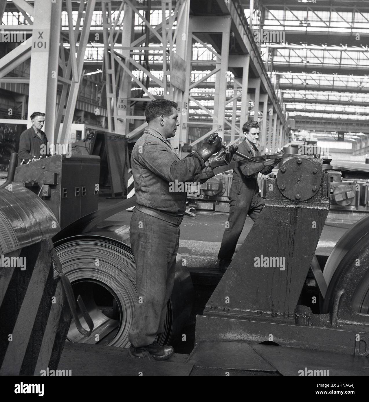 1950s, historical, workers on an industrial factory floor pressing ...