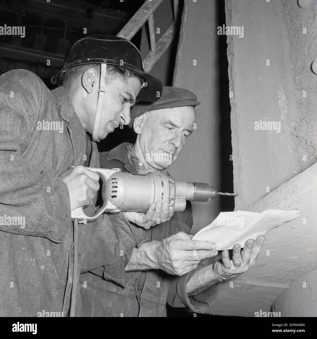 1950s, historical, two workers doing building work at a steel factory ...
