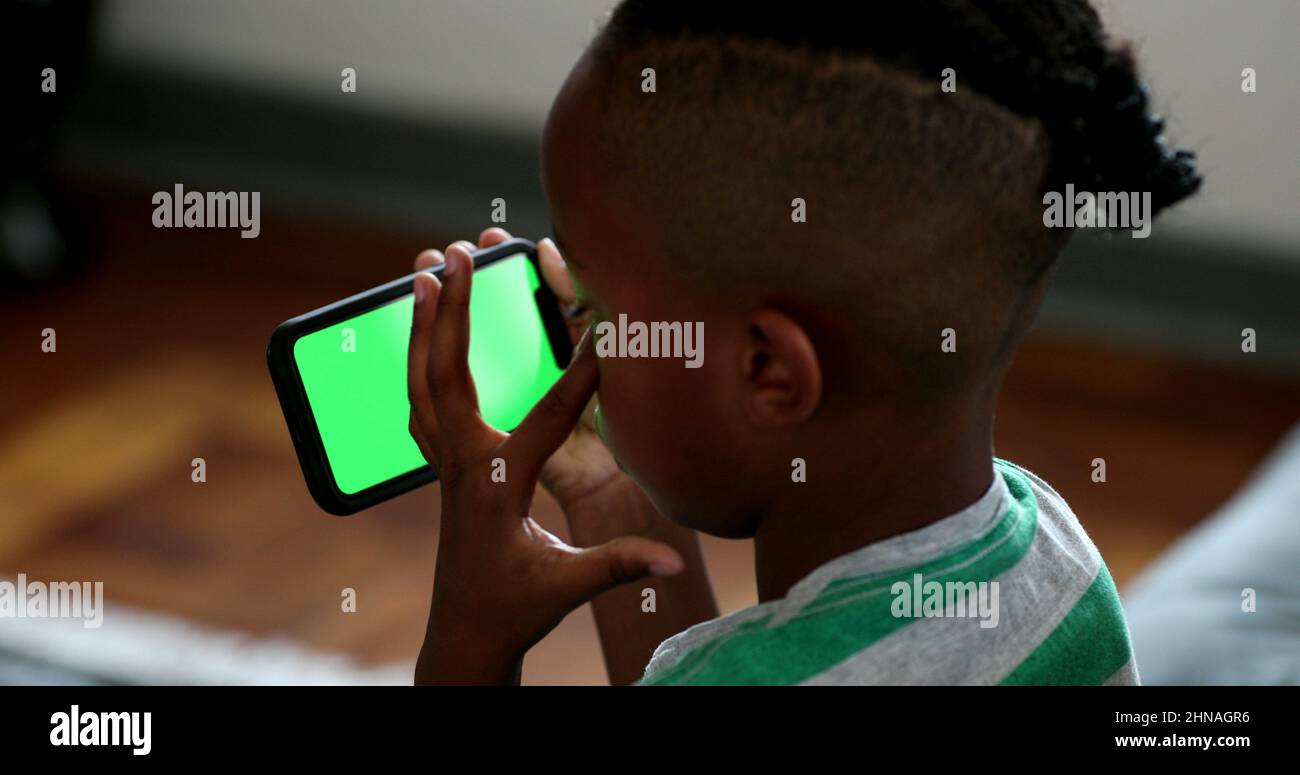 Child scratching face while using cellphone blank screen Stock Photo ...