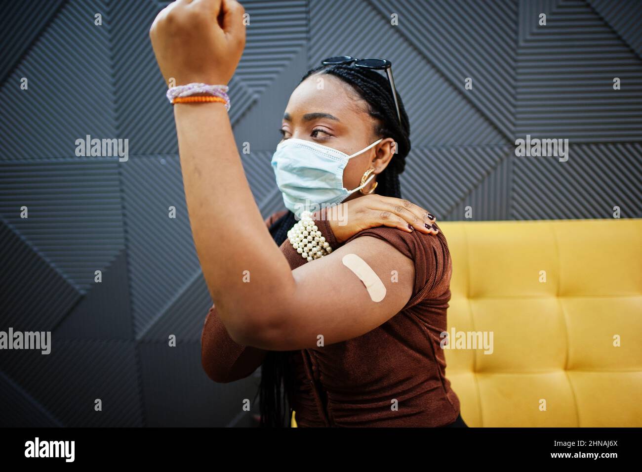 Stay safe! Black woman, wearing mask, showing vaccinated arm after ...