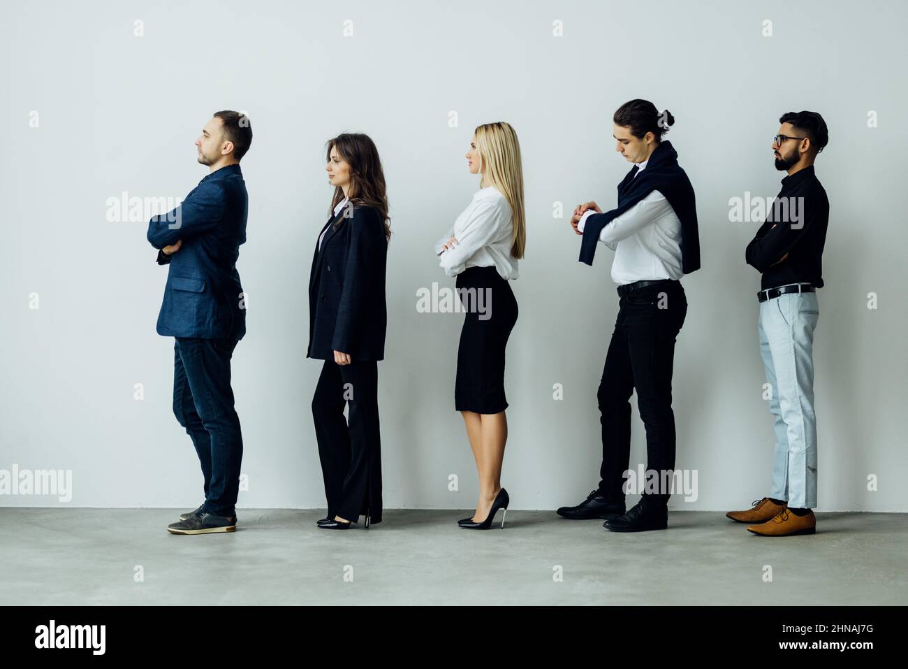 Full length side view of business people walking against white ...