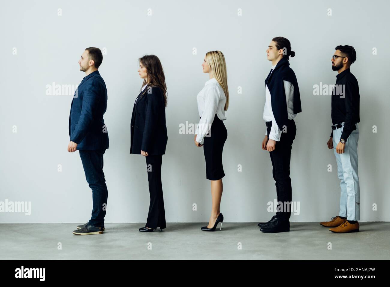 Full length side view of business people walking against white ...