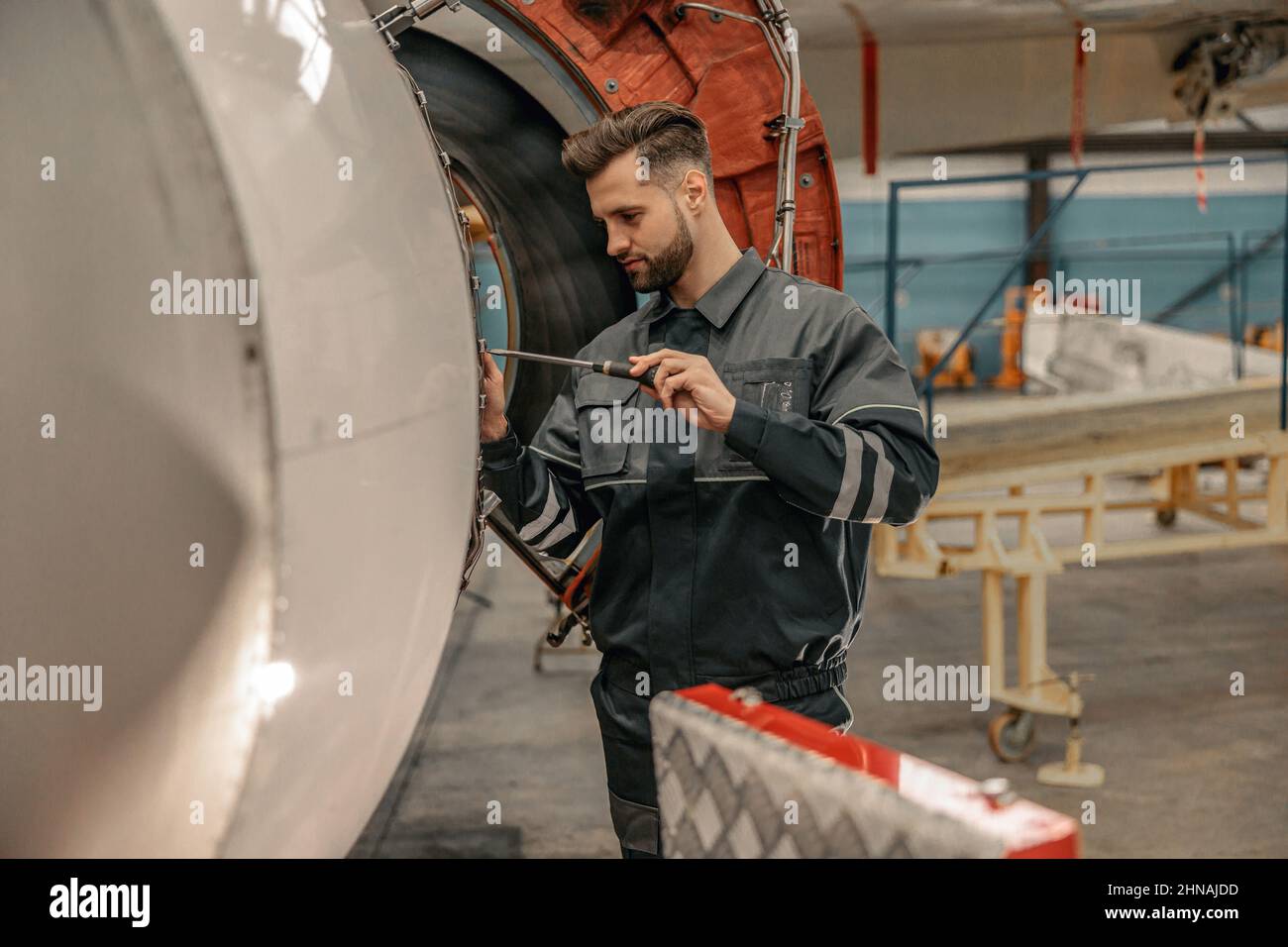 Male aviation mechanic repairing airplane in hangar Stock Photo - Alamy