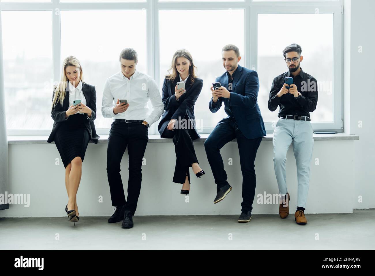 Conceptual photo multi ethnic young people sit in queue holding ...