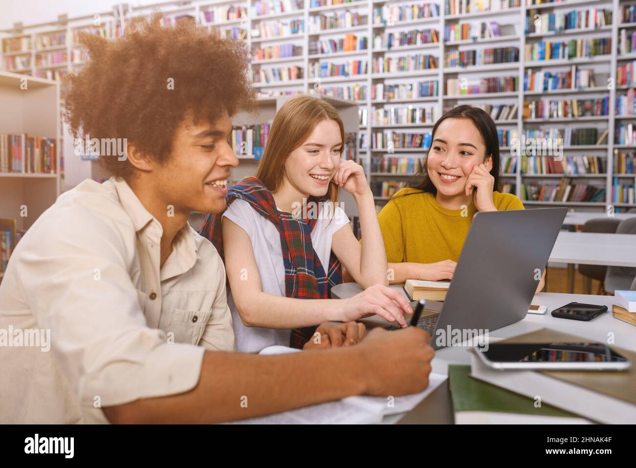 University students are studying in a library together as teamwork for ...