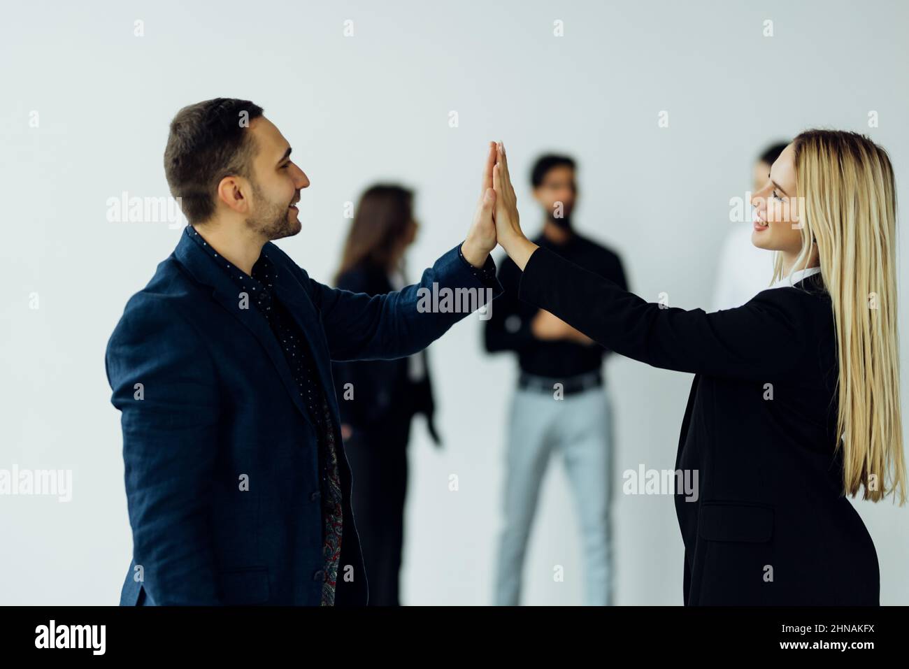Two happy successful young managers giving high five Stock Photo - Alamy
