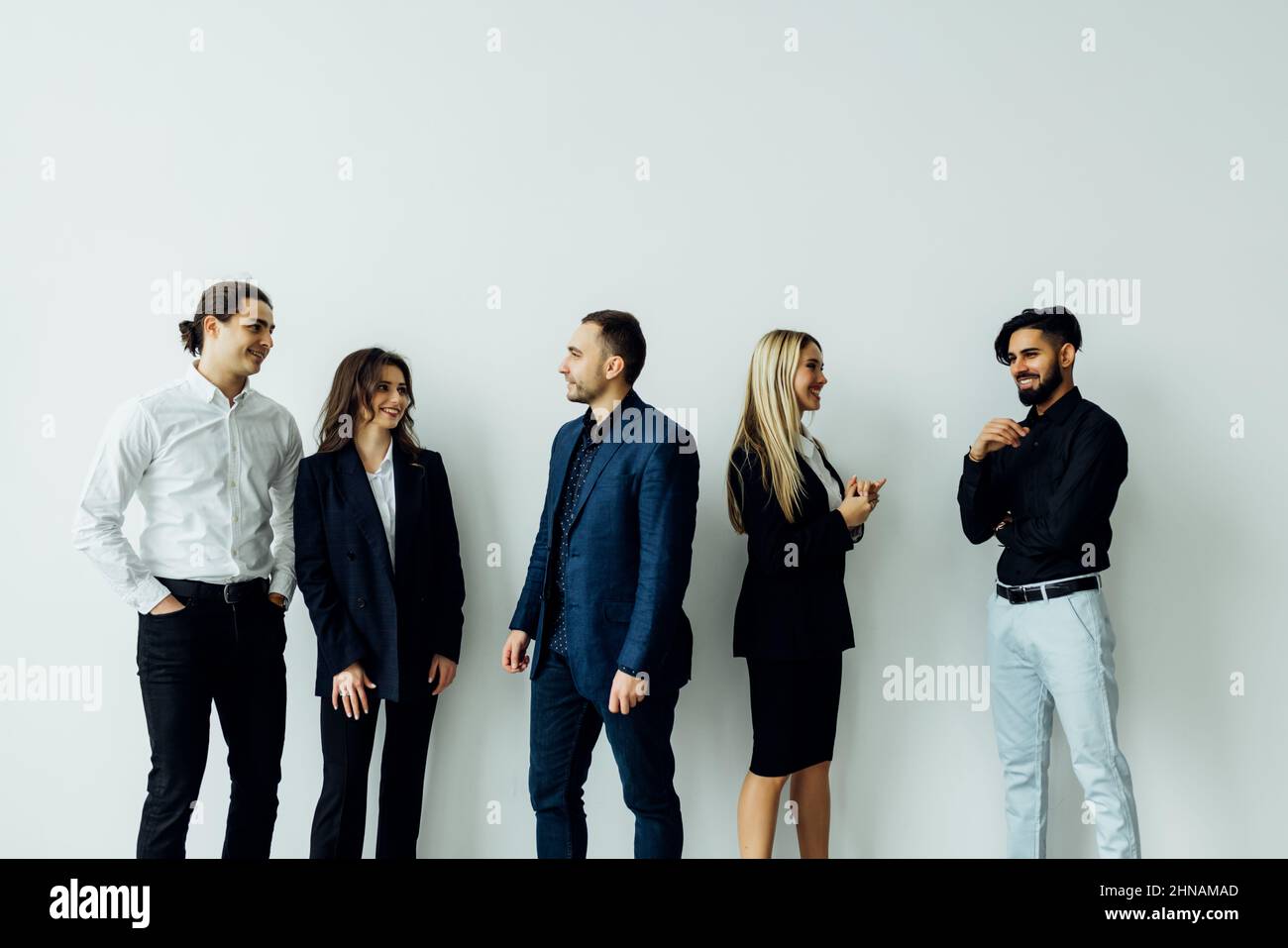 Portrait of standing in row smiling diverse team posing differently ...