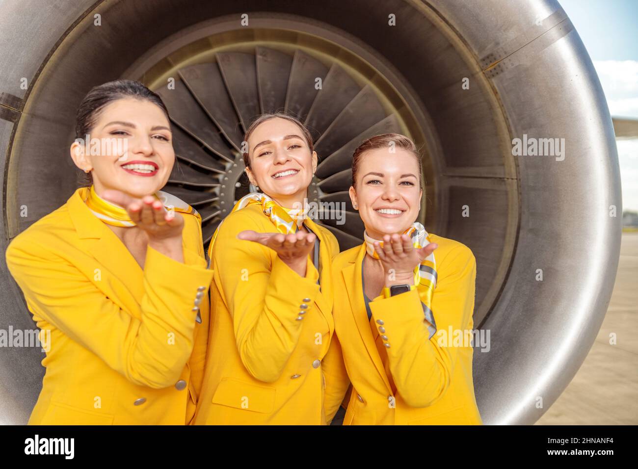 Joyful women stewardesses standing near aircraft engine Stock Photo - Alamy