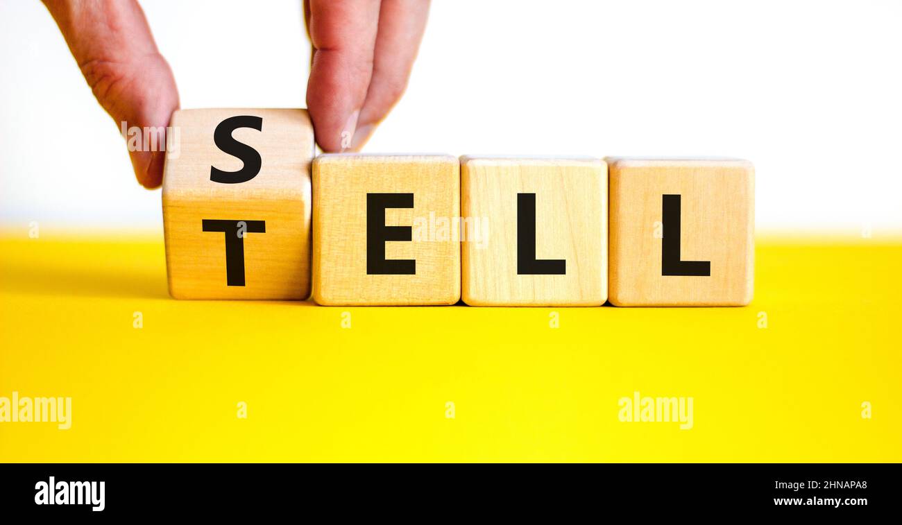 Sell or tell symbol. Businessman turns a wooden cube and changes the ...