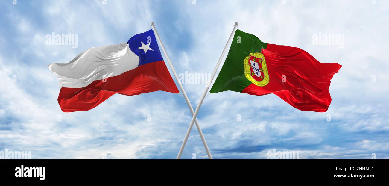 crossed national flags of Chile and portugal flag waving in wind at ...
