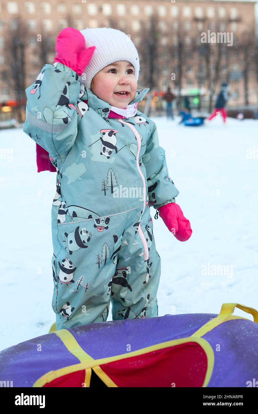 Little frozen girl is ready for riding on snow tubing from slope in ...