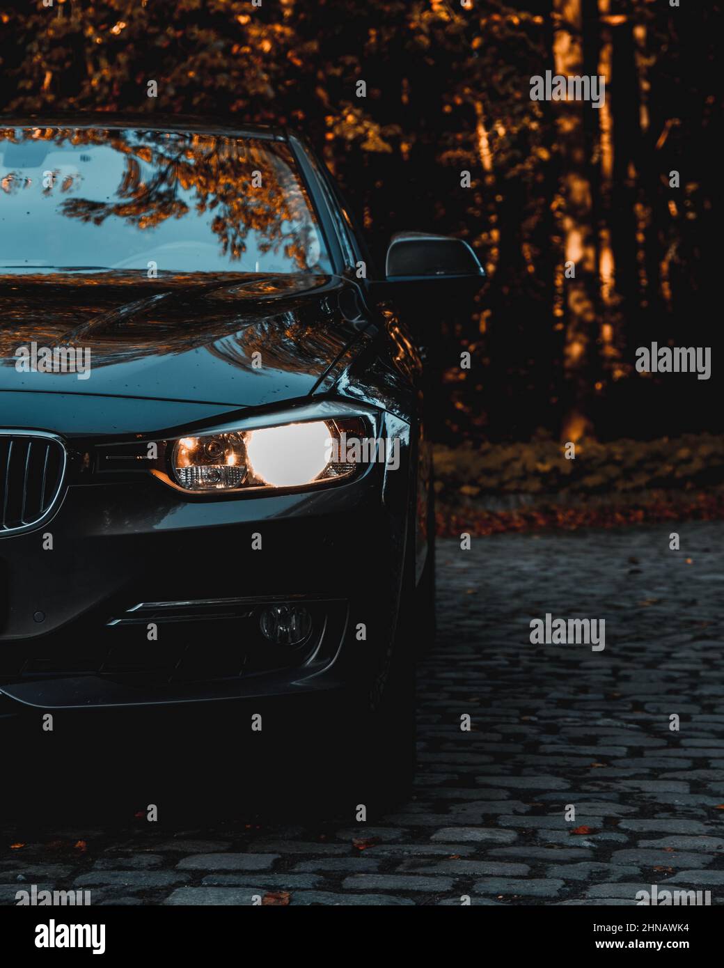 Vertical shot of a modern car on the cobblestone street Stock Photo - Alamy