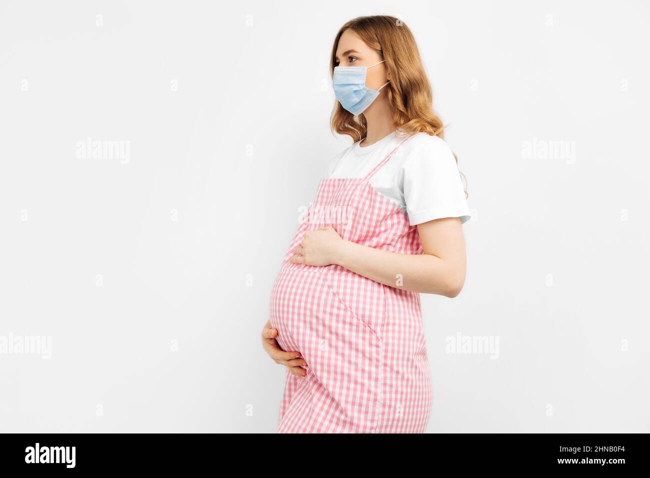 pregnant woman wears a medical protective face mask due to illness ...