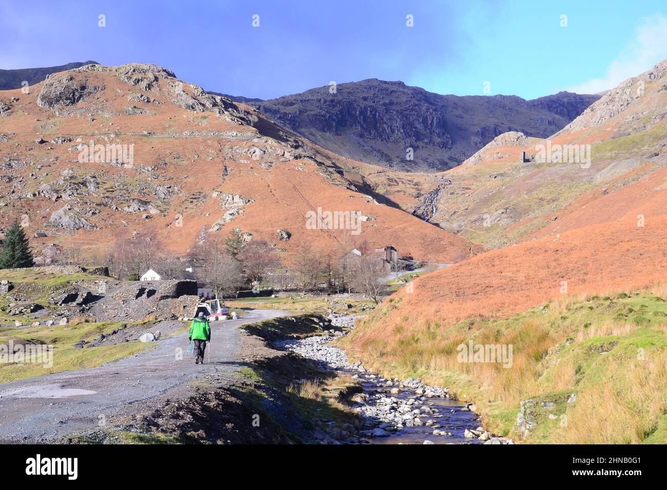 A man walks down a path of the mountain in the valley of Coniston ...