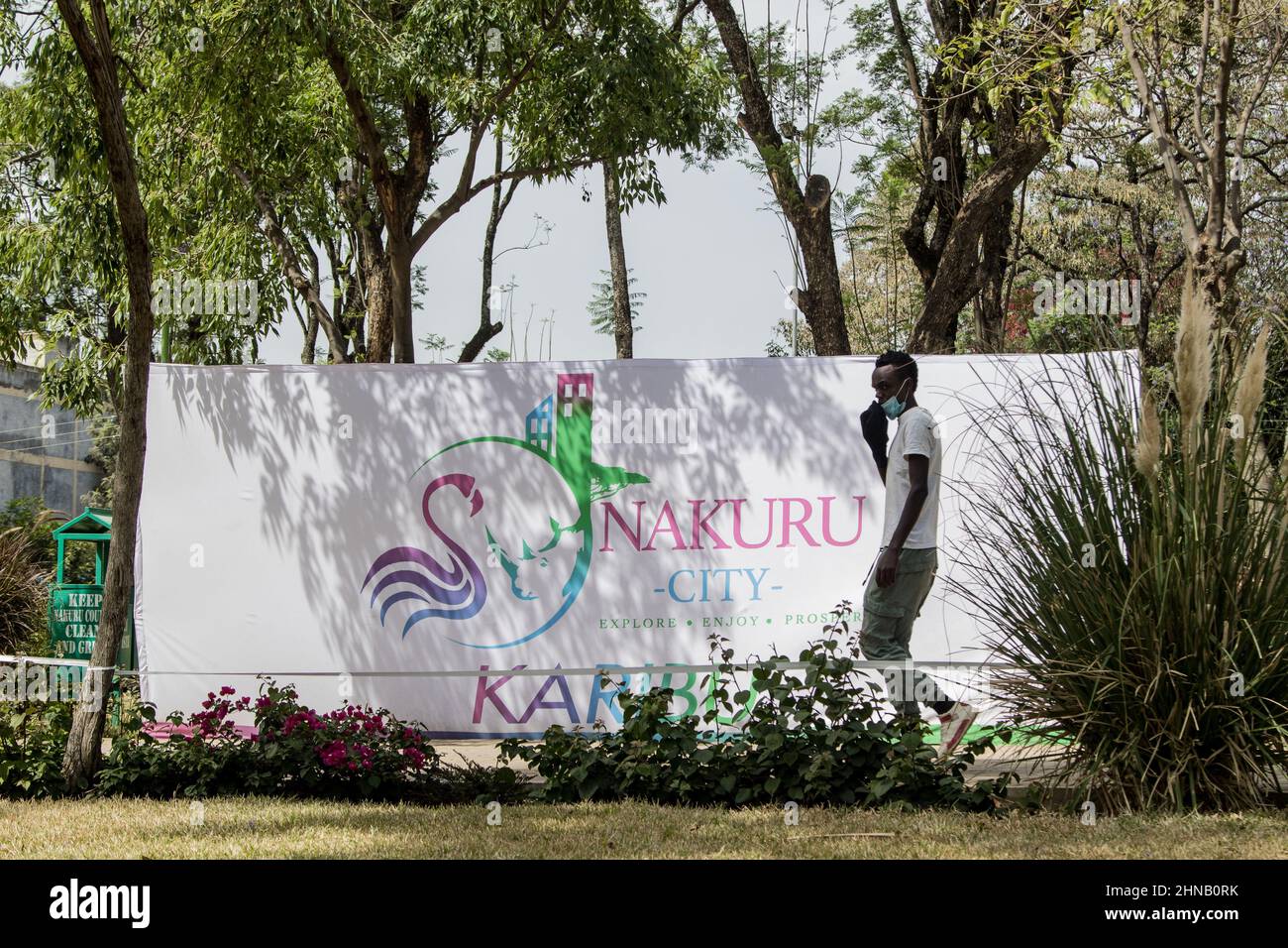Nakuru, Kenya. 15th Feb, 2022. A man walks past a banner of Nakuru City ...