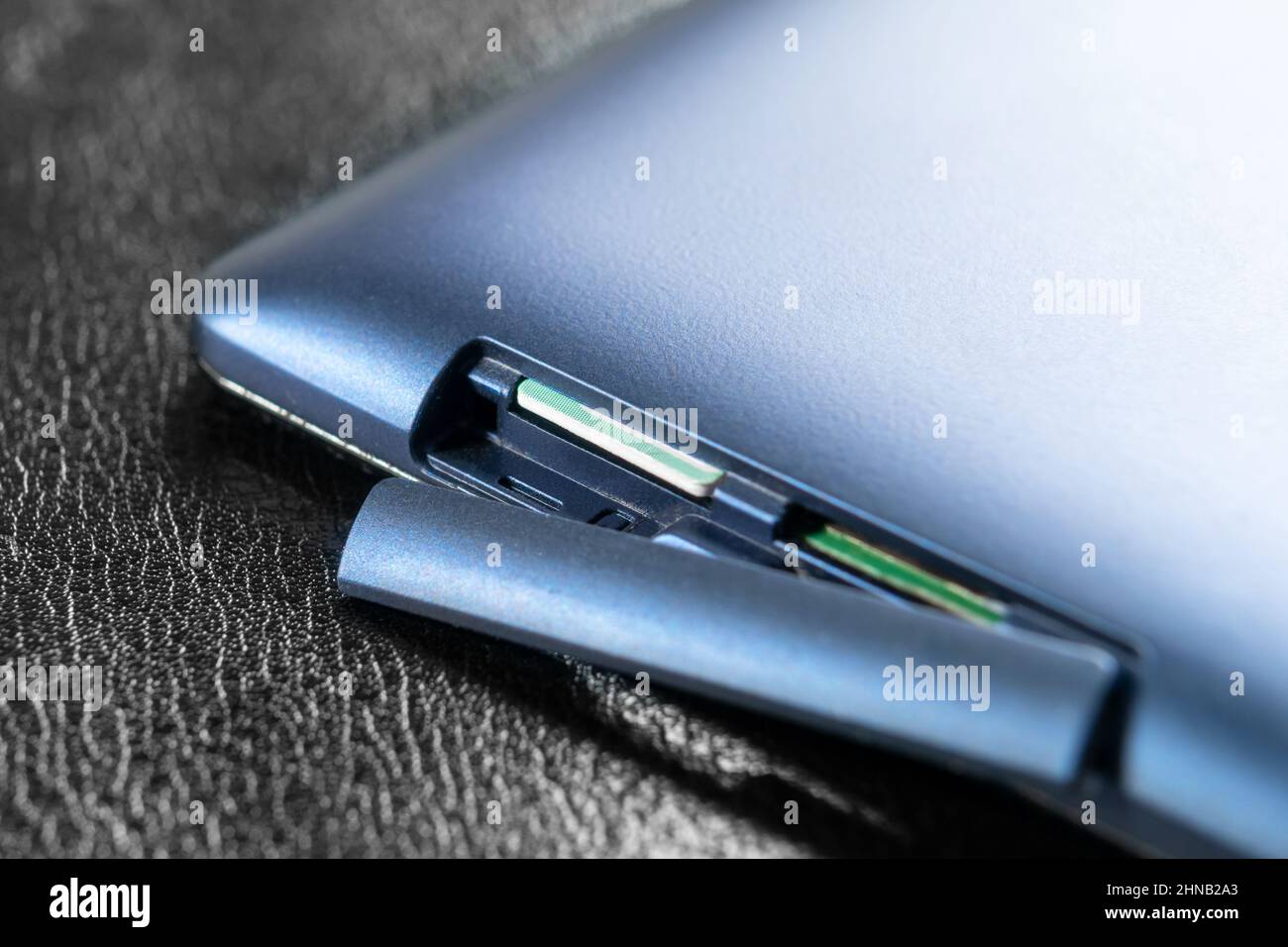 Sim card in an open tablet terminal close-up. Port of a blue electronic ...